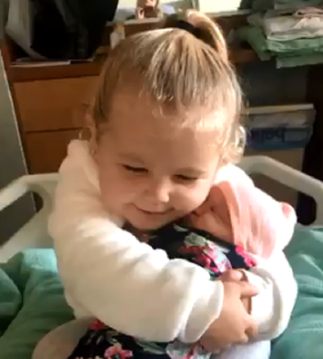 Toddler holds newborn baby sister for 1st time uttering vow of protection