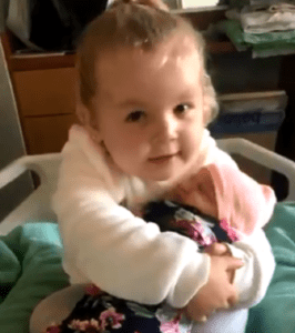 Toddler holds newborn baby sister for 1st time uttering vow of protection