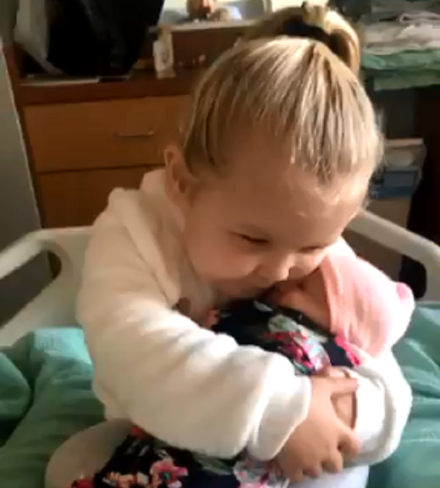 Toddler holds newborn baby sister for 1st time uttering vow of protection