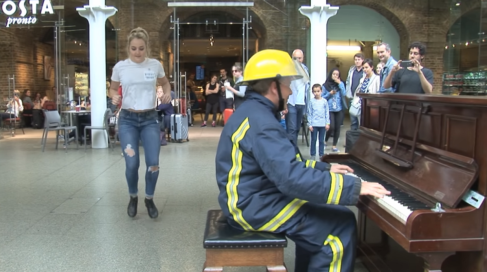 Fireman draws a crowd carrying young woman to piano