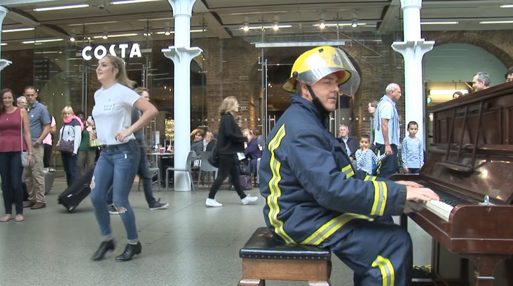 Fireman draws a crowd carrying young woman to piano