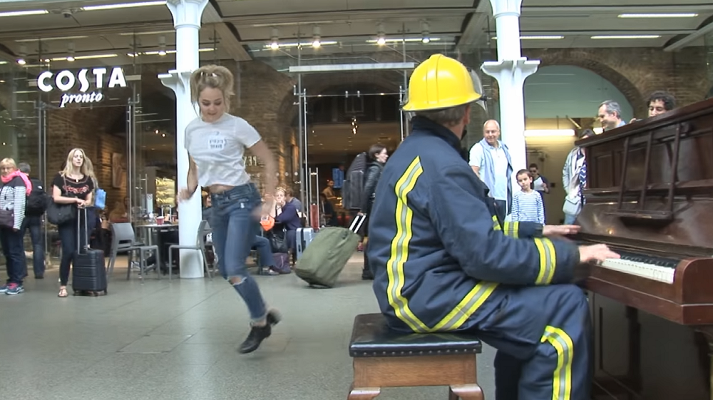 Fireman draws a crowd carrying young woman to piano