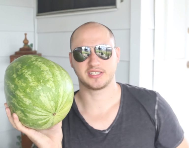 Guy demonstrates how to open up a watermelon using just a quarter