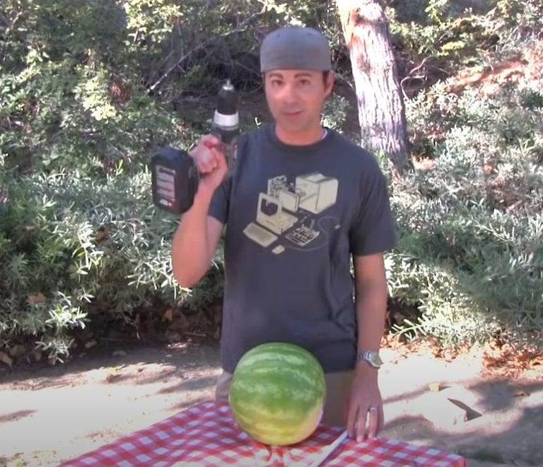 Guy demonstrates how to open up a watermelon using just a quarter