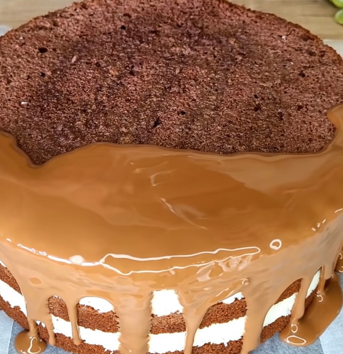 Woman layers chocolate cake with thick coconut filling for delicious ...