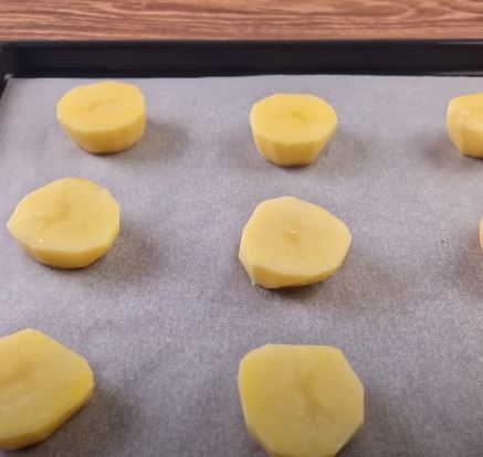 Woman places drumsticks on top of potato slices for an incredibly ...