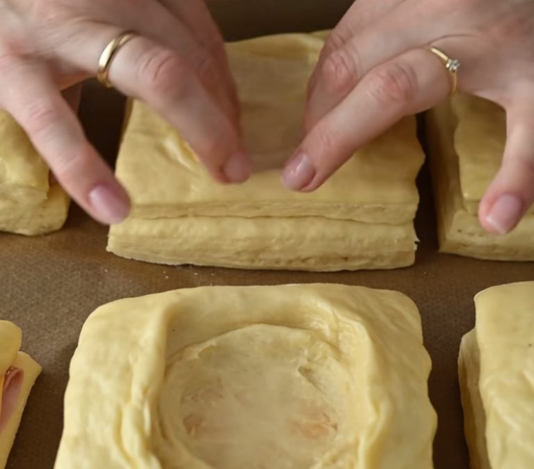 Add cheese and ham between sheets of buttered dough and top with egg ...