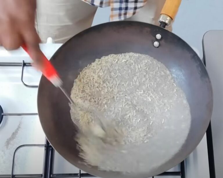 Teacher pours rice into a frying pan with salt to show how to make ...